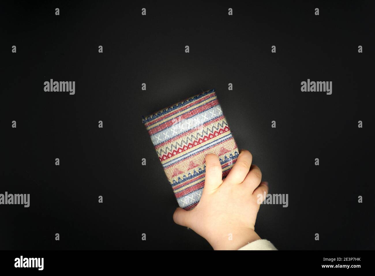 child's hand grabbing box on black background. flat lay flat design ...