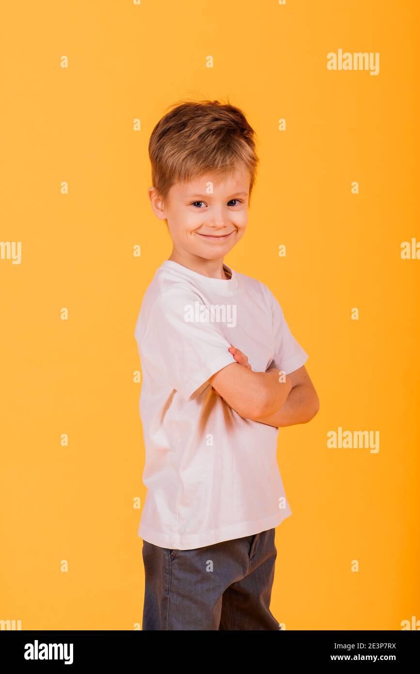 Portrait of happy little boy over yellow background in studio Stock ...