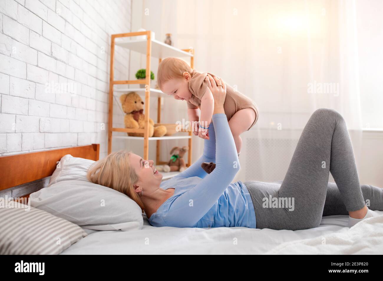 Happy young mother lifting her cute little baby up Stock Photo - Alamy