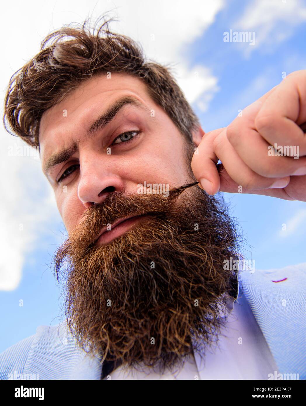 Hipster handsome attractive guy close up. Man bearded hipster twisting ...