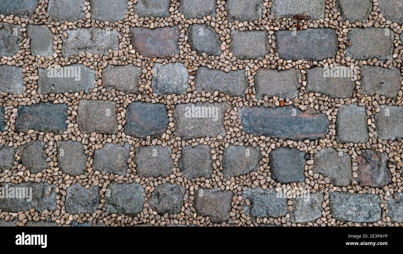 Blue grey stone setts layed within a bed of shingle Stock Photo - Alamy