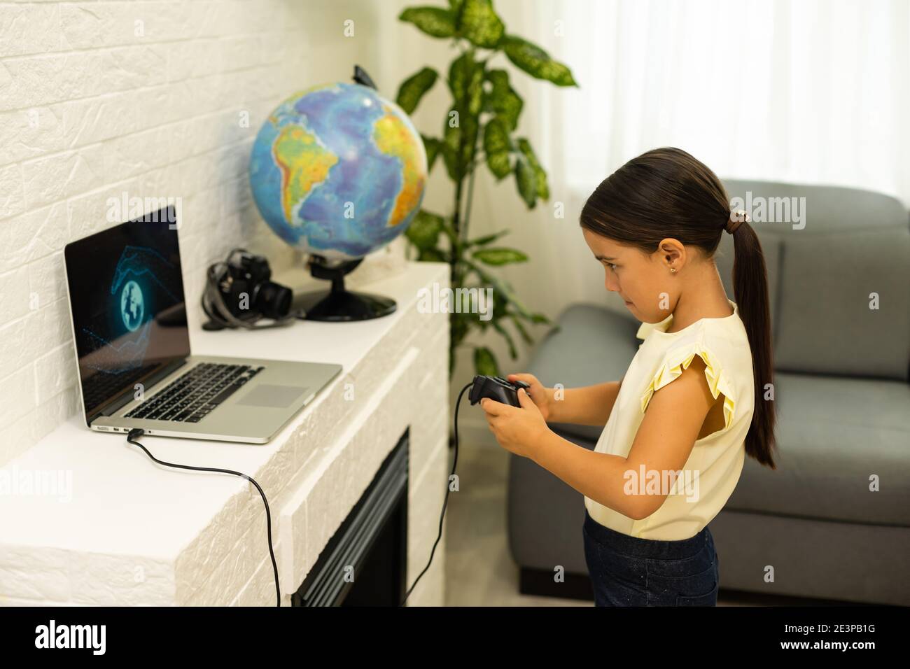 little girl playing games with laptop computer and joystick controller ...