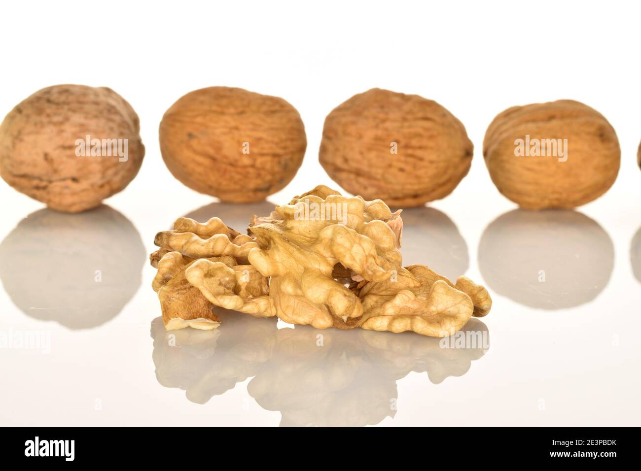 A few whole light yellow tasty peeled walnut kernels, in focus ...