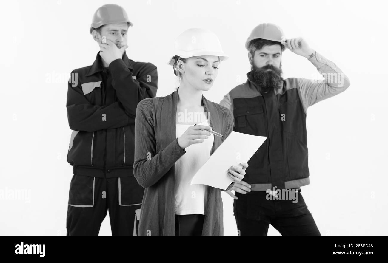 Team of architects, builders with woman manager looks at document ...