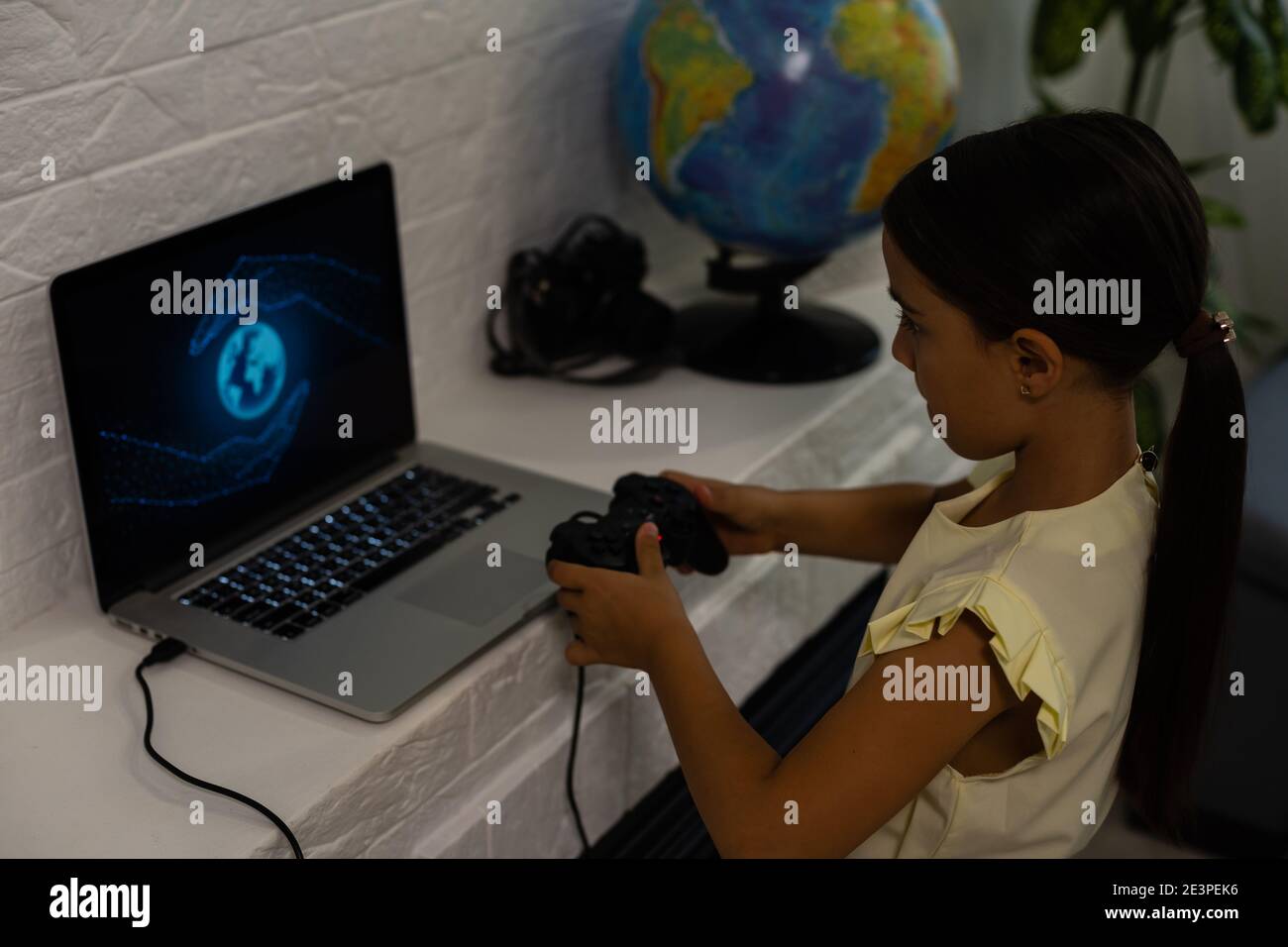 little girl playing games with laptop computer and joystick controller ...