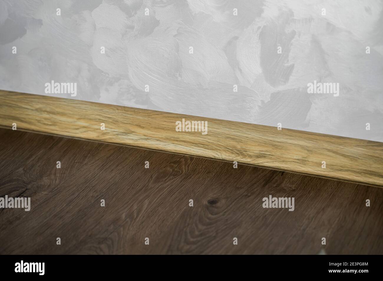 Laminate with plastic baseboard with a wooden texture. Newly installed ...