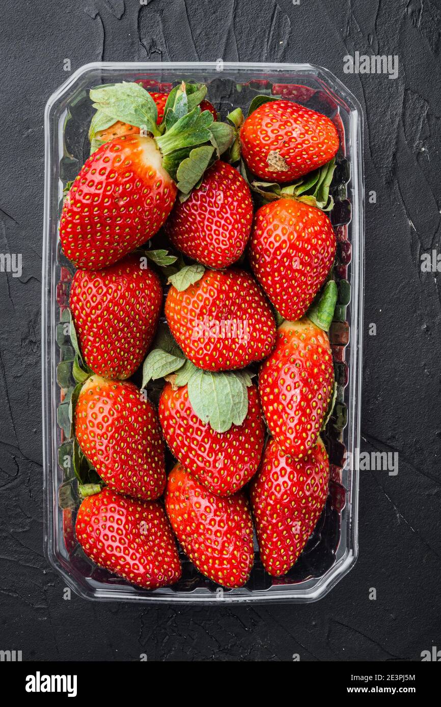 Transparent plastic tray, with freshly picked strawberries, on black ...