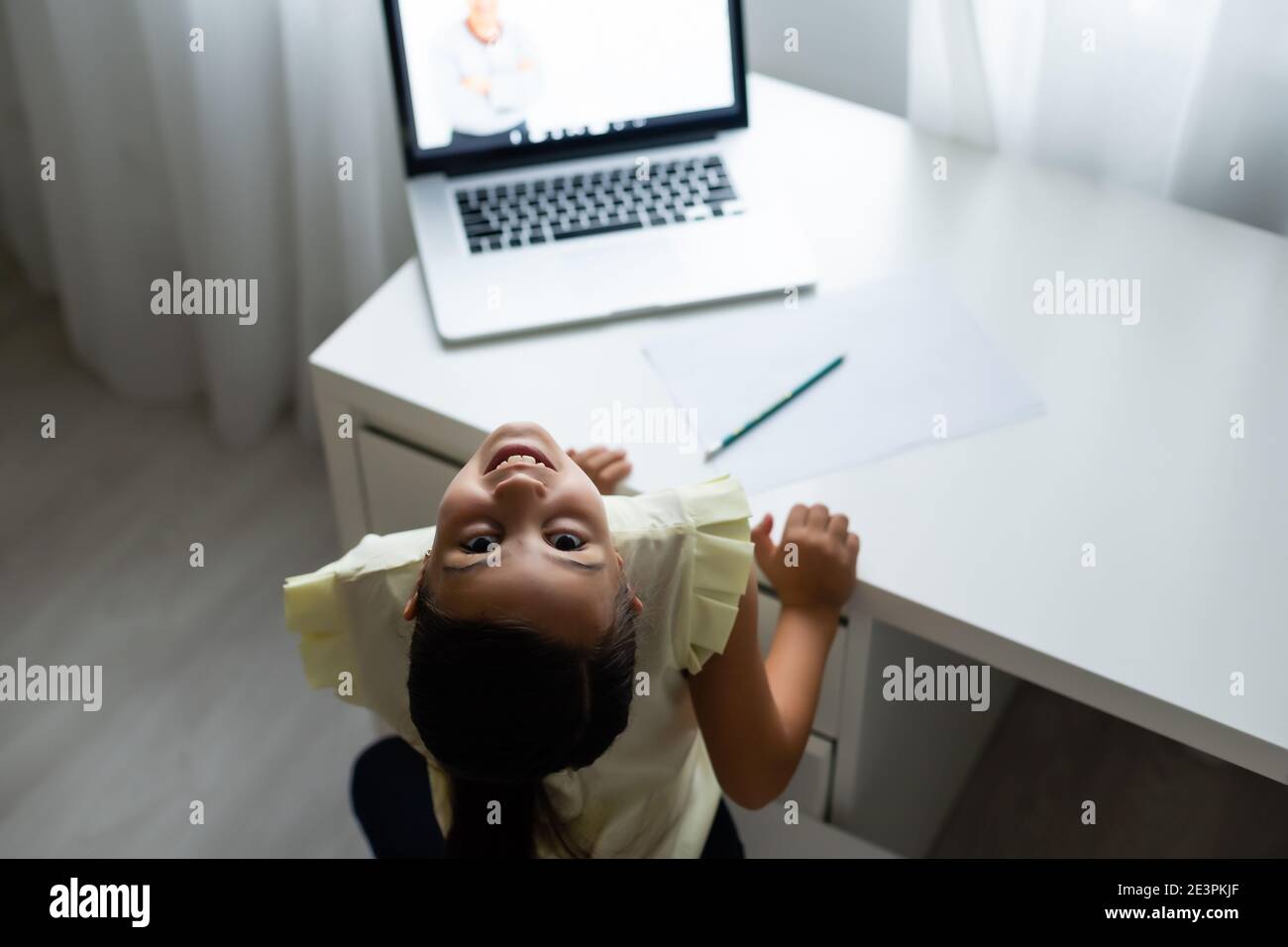 Litttle girl looking at laptop screen with expression of surprised and ...