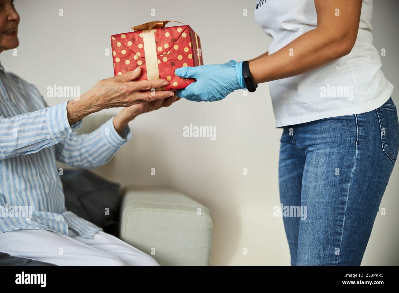 Person passing a birthday package to an old female Stock Photo - Alamy