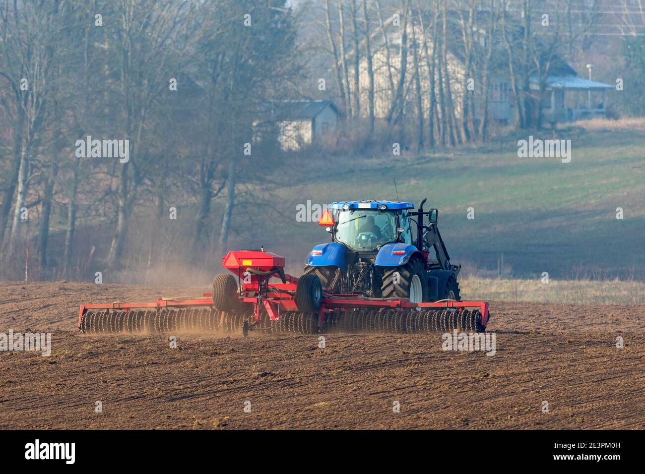 Tractor with a roller on the field at spring Stock Photo - Alamy