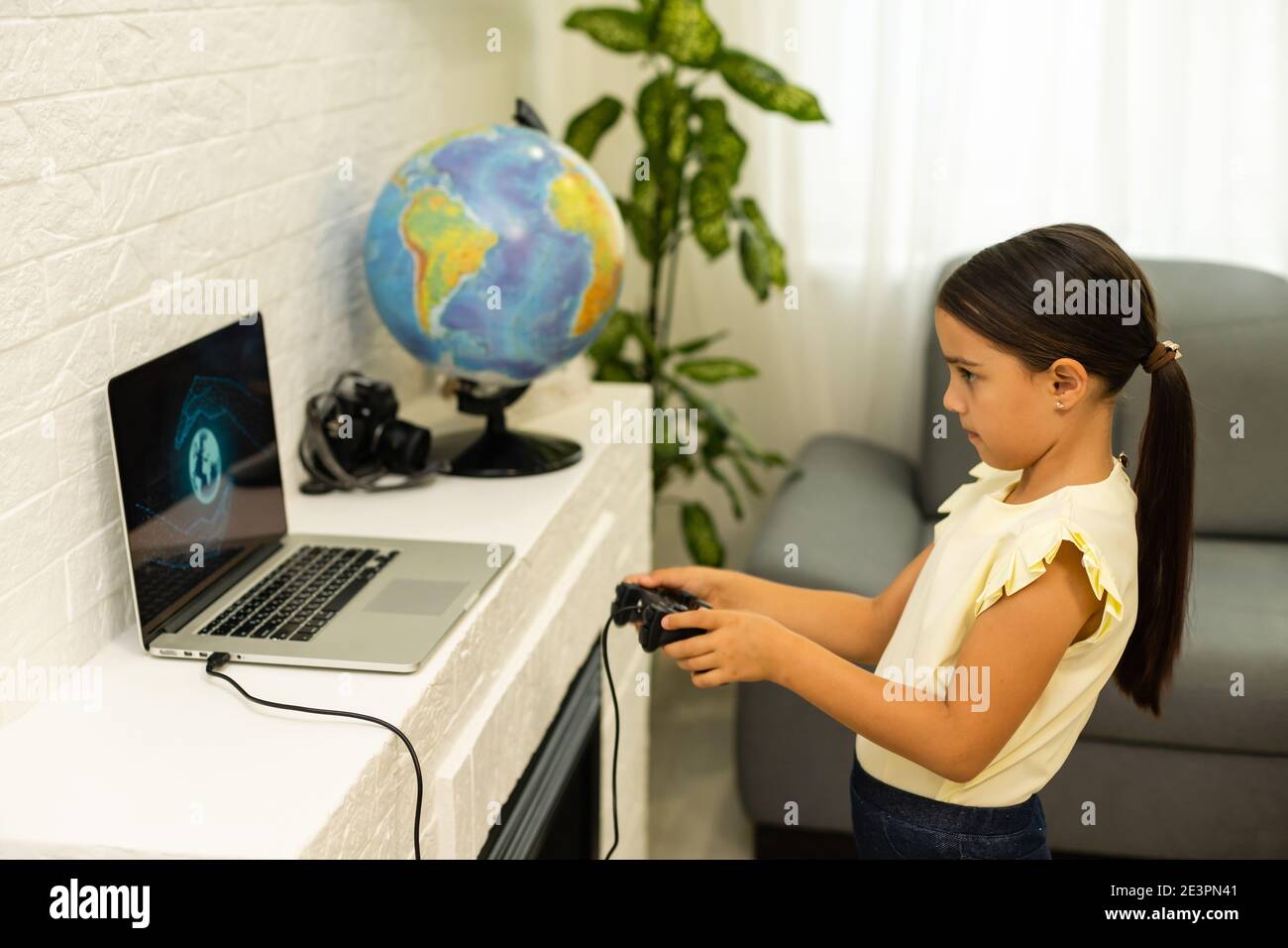 little girl playing games with laptop computer and joystick controller ...
