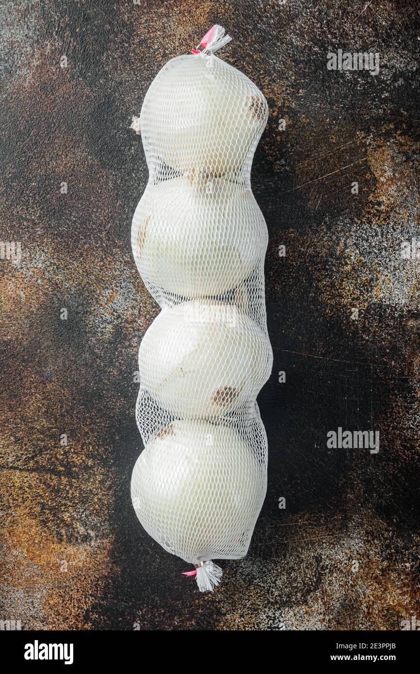 White onions in a grid, on old dark rustic background, top view flat ...
