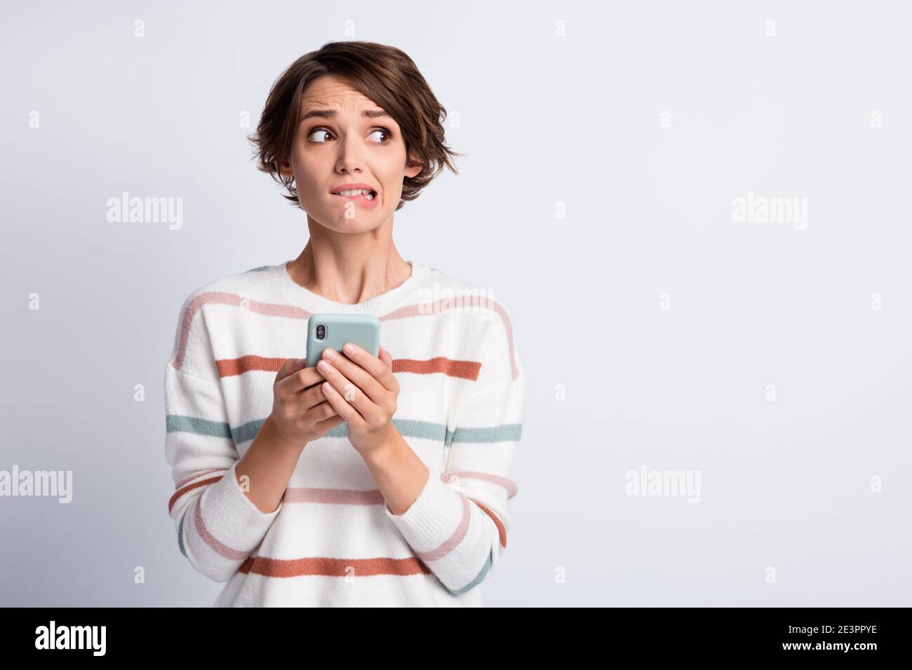 Photo of guilty sad young woman dressed striped pullover holding modern ...