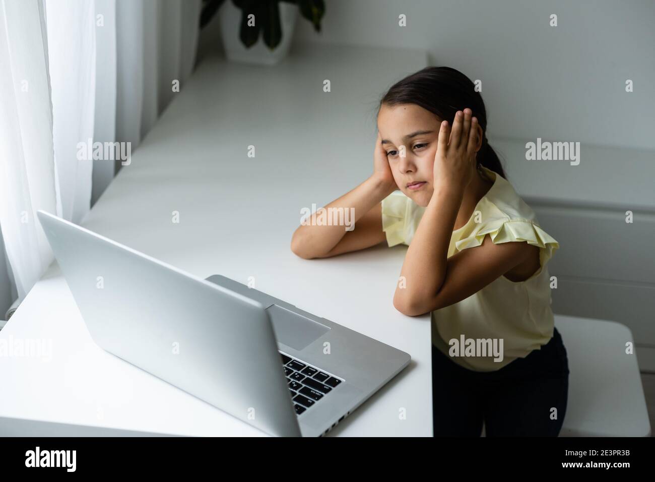 Litttle girl looking at laptop screen with expression of surprised and ...