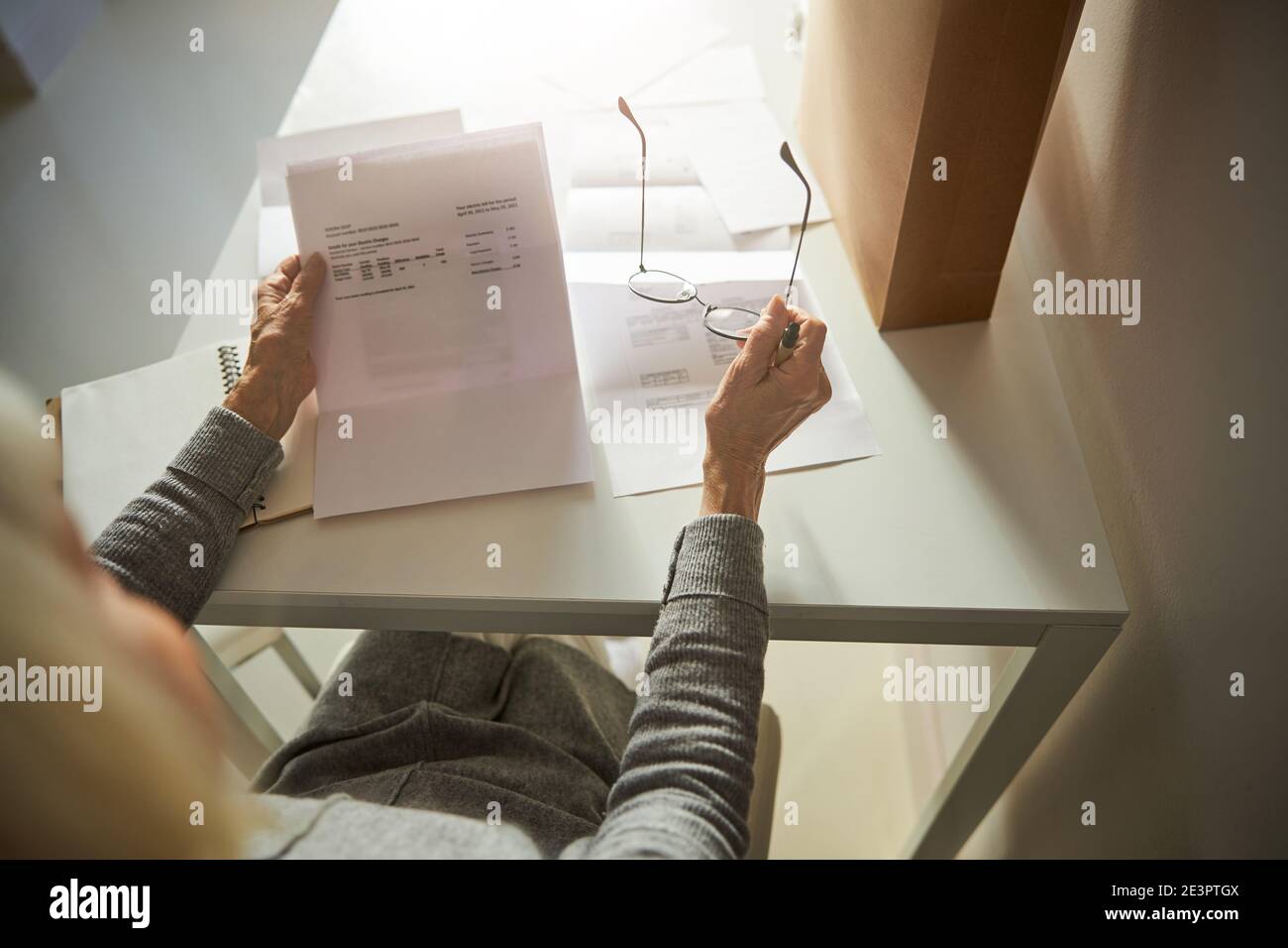 Senior lady perusing a utility bill in the kitchen Stock Photo - Alamy