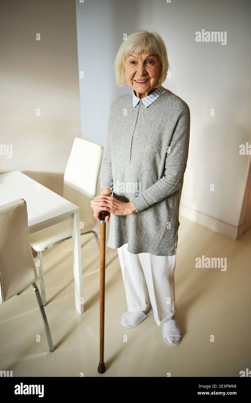 Joyous aged lady with a cane looking ahead Stock Photo - Alamy