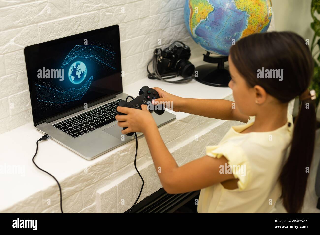little girl playing games with laptop computer and joystick controller ...