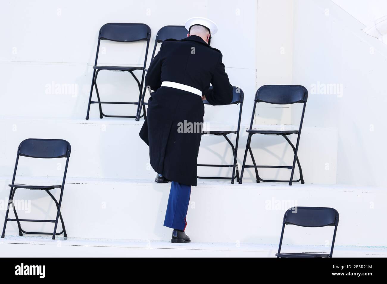 A man organizes chairs on stage ahead of the Inauguration Day ceremony ...
