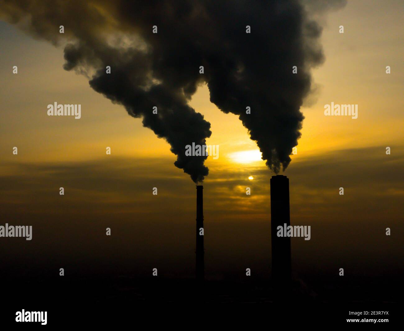 Power Plant emissions seen above the city during sunrise. Environmental ...