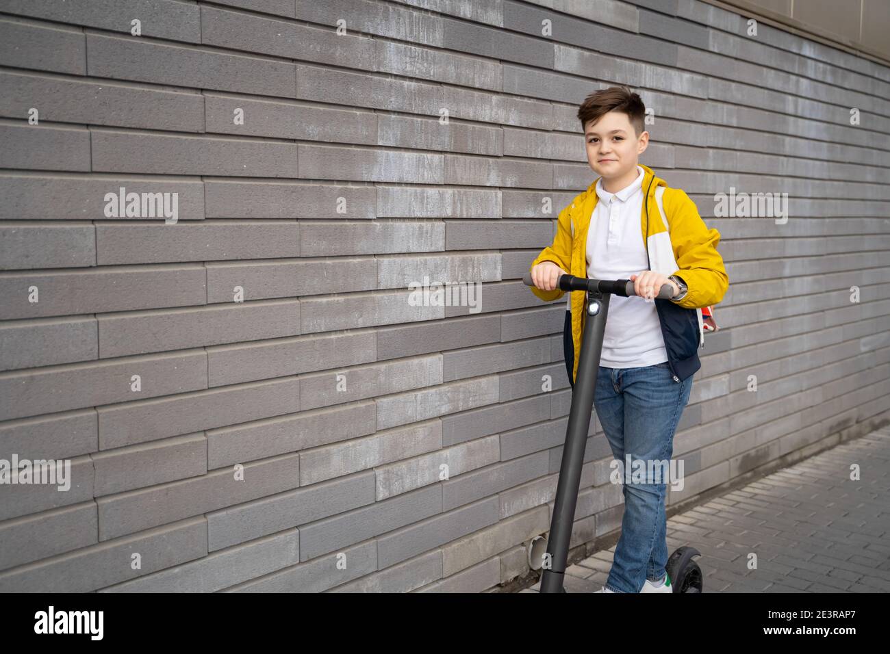 Handsome teenager rides on electric scooter down the city street Stock ...