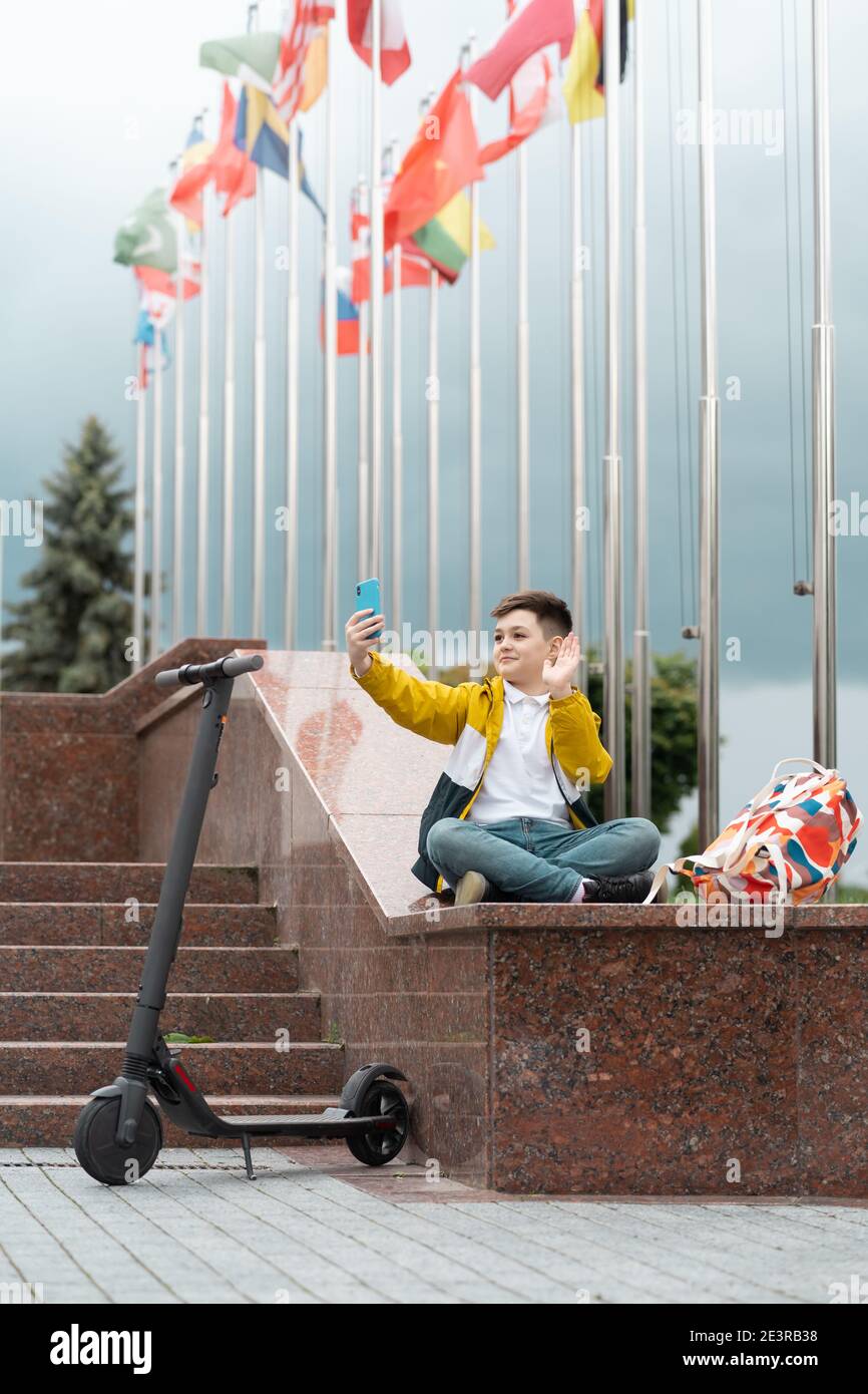 Teenager sits near the administration building against background of ...