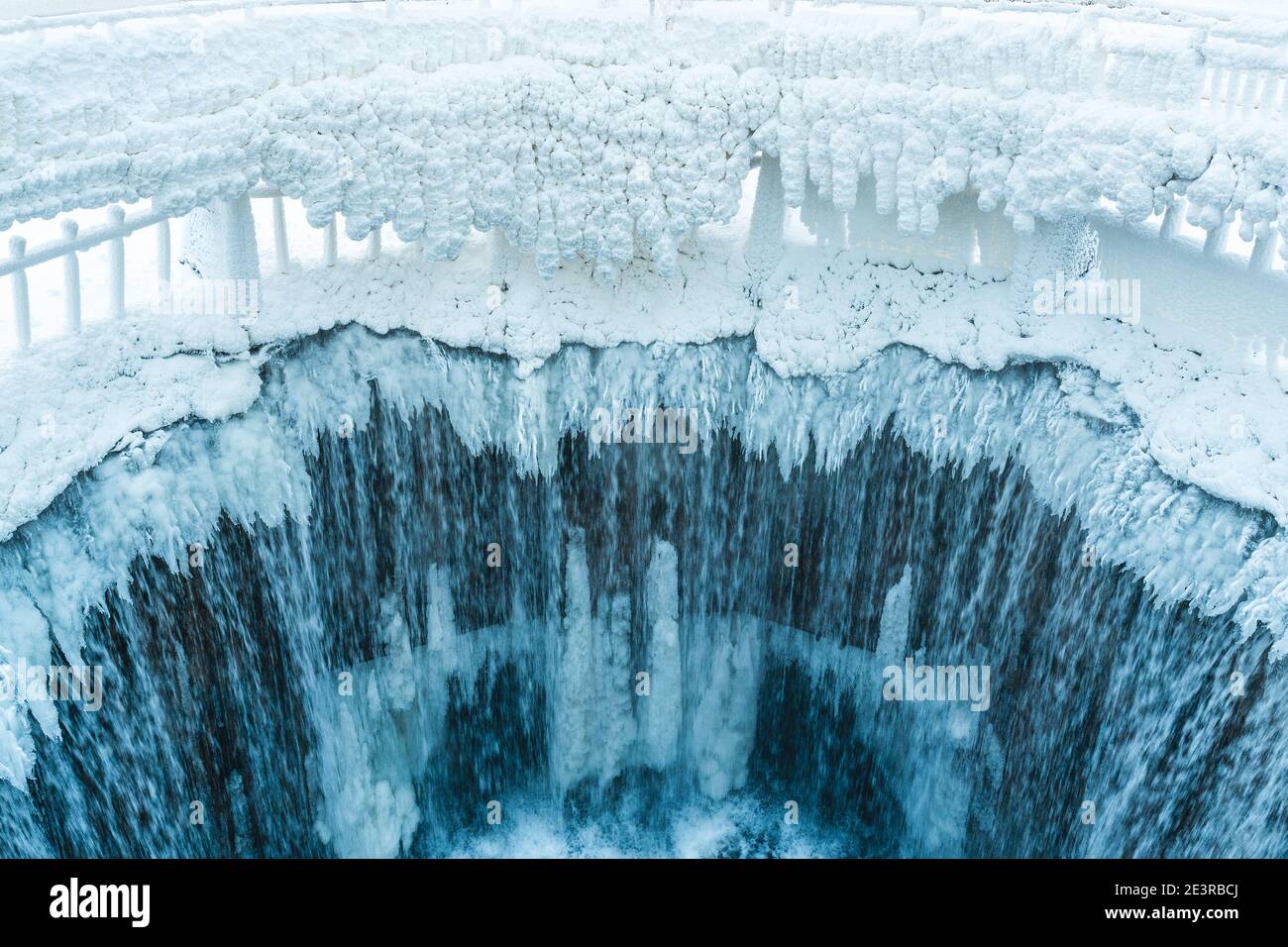 Frozen waterfall flowing through a small dam. Winter background Stock ...
