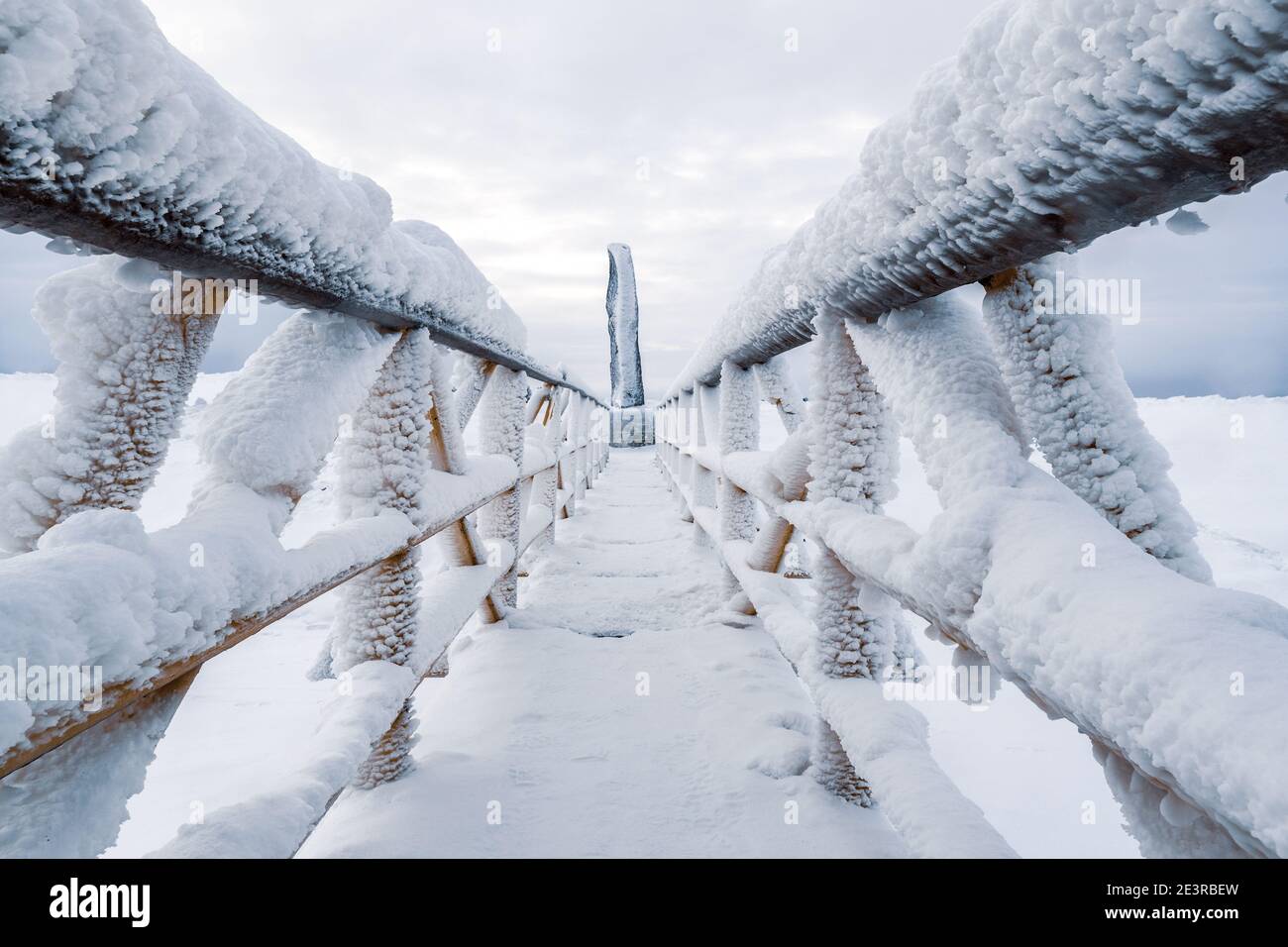 Metal bridge with handrails covered with snow and ice. Extremely cold ...