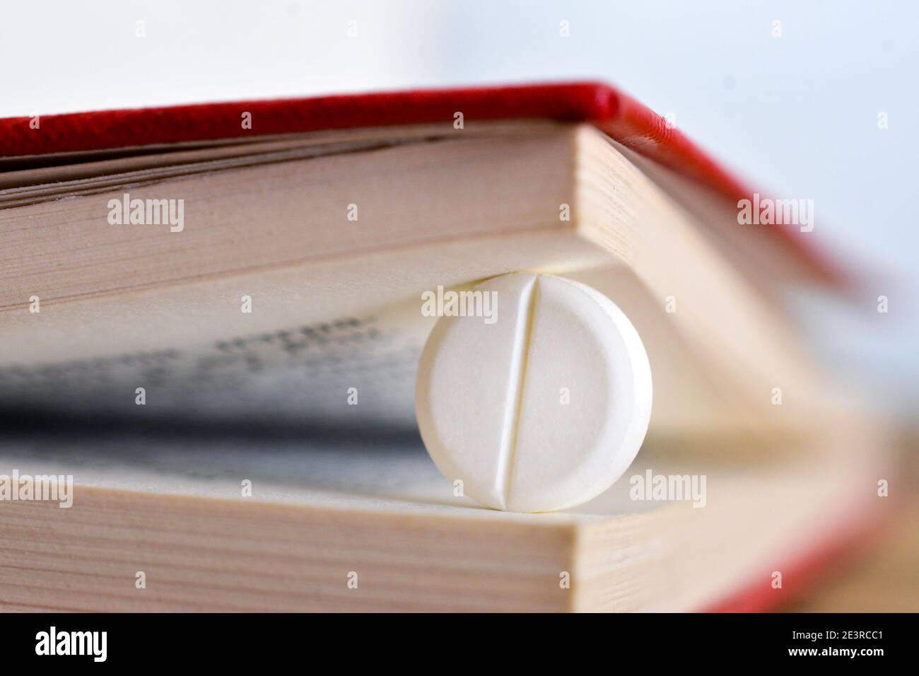 white tablette pill between book pages Stock Photo - Alamy