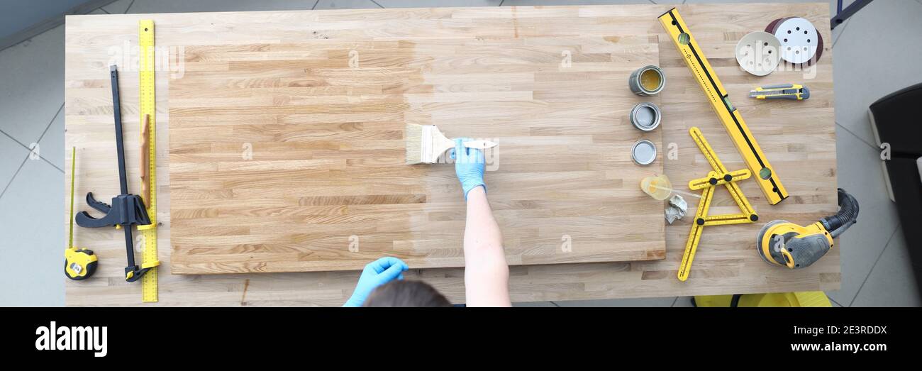 A man polishing a board with varnish top view Stock Photo - Alamy