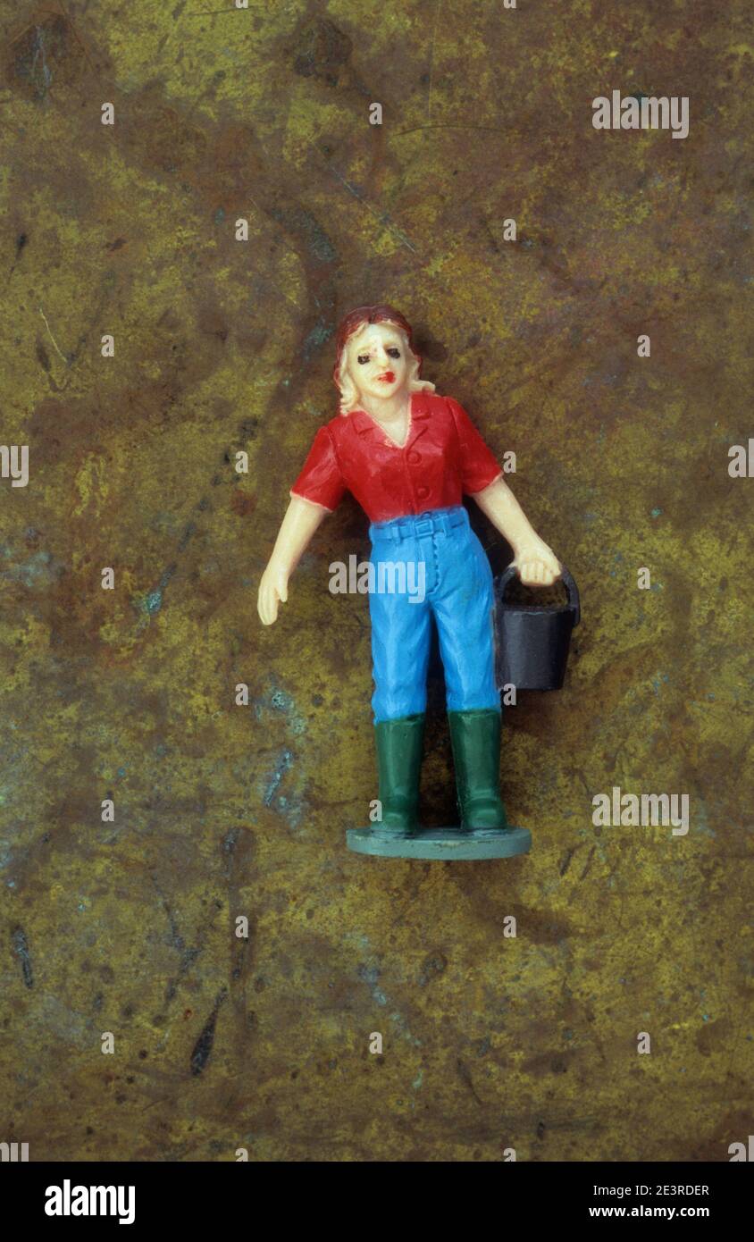 Plastic model of female farm or stable worker in jeans and rubber boots ...