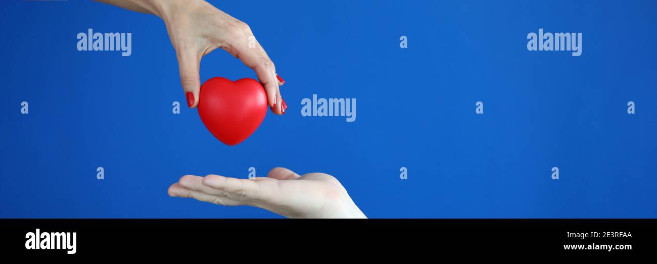 Hands pass red heart heart disease concept Stock Photo - Alamy
