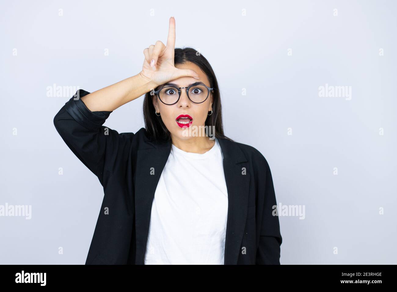 Beautiful business woman making fun of people with fingers on forehead ...