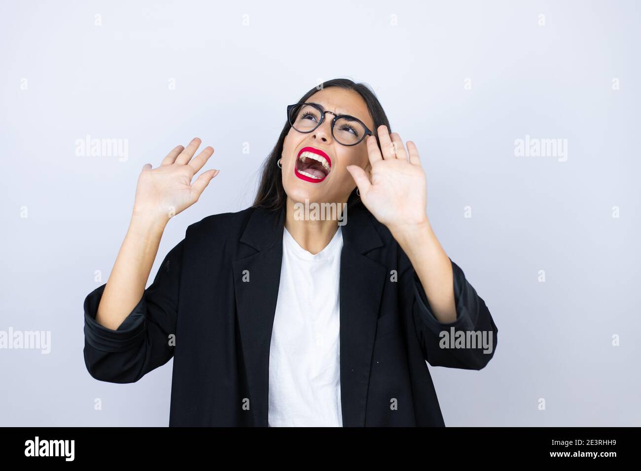 Beautiful business woman scared with her arms up like something falling ...