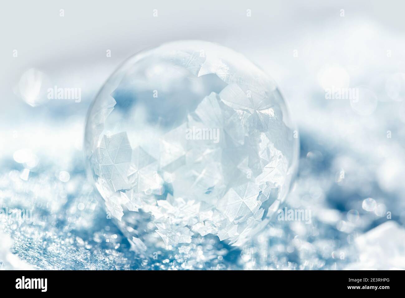 frozen bubble with bokeh background. Beautiful frosty patterns on frozen soap bubble. winter ...