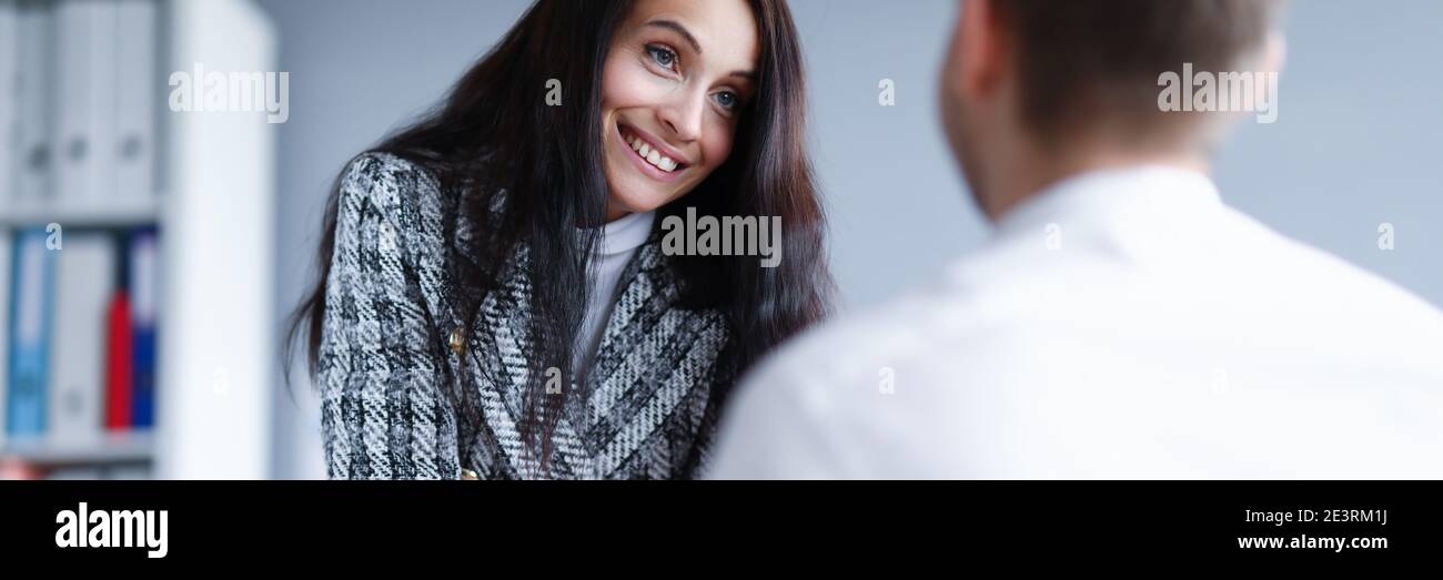 Woman smiling at a man standing in the office Stock Photo - Alamy