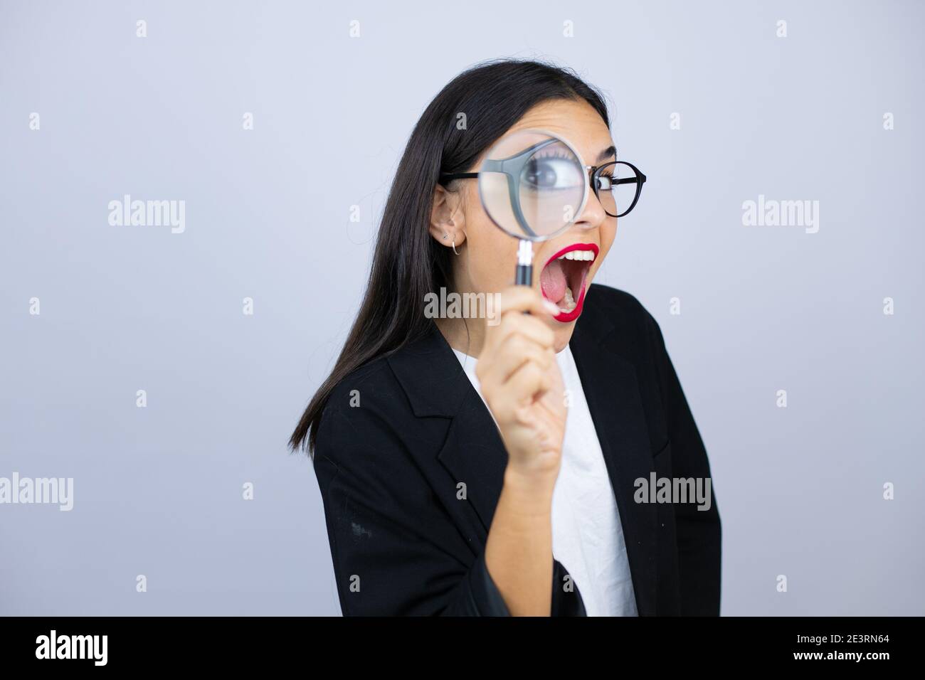Beautiful business woman looking through a magnifying glass Stock Photo ...
