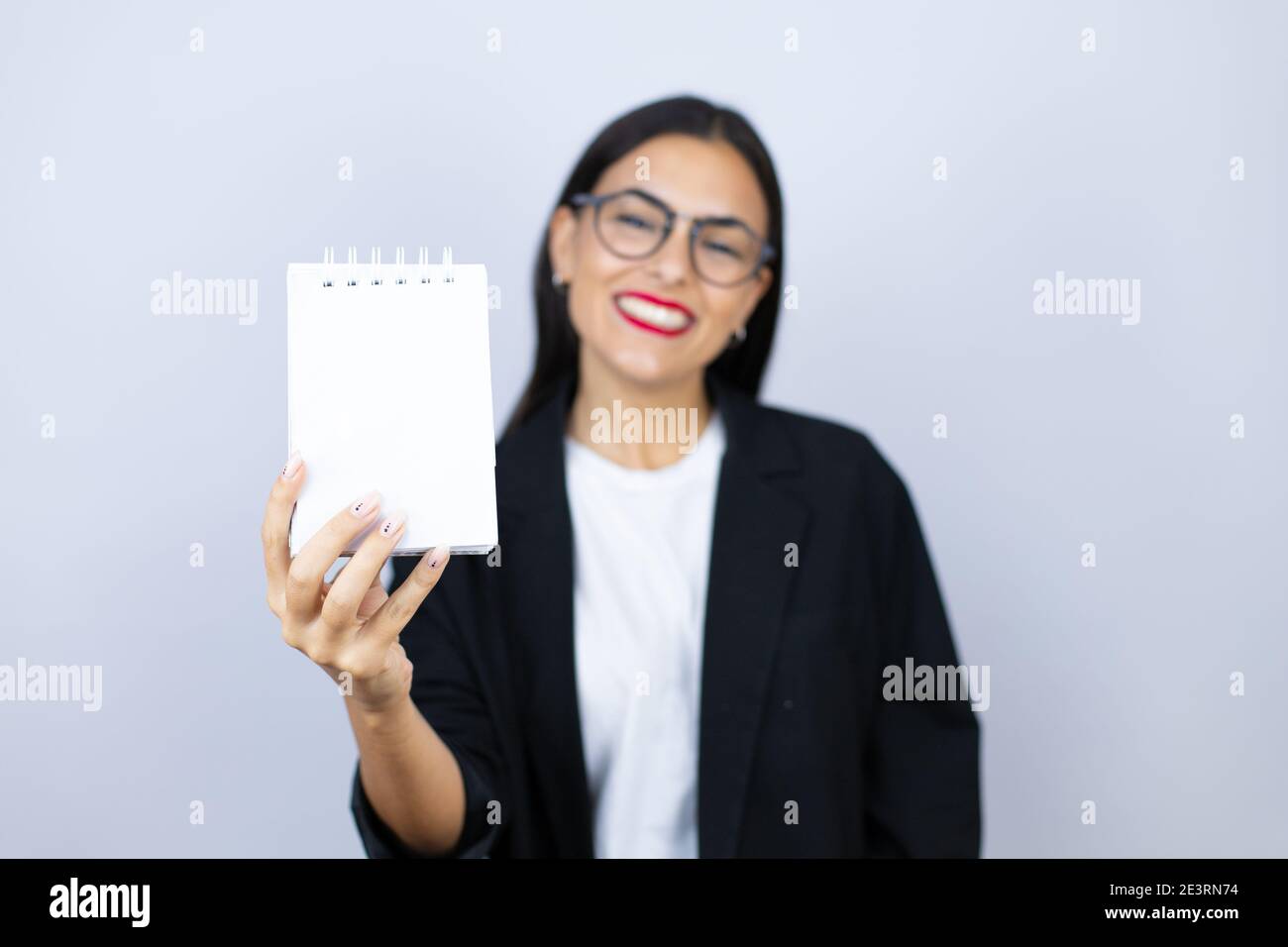 Beautiful business woman smiling showing blank notebook Stock Photo - Alamy