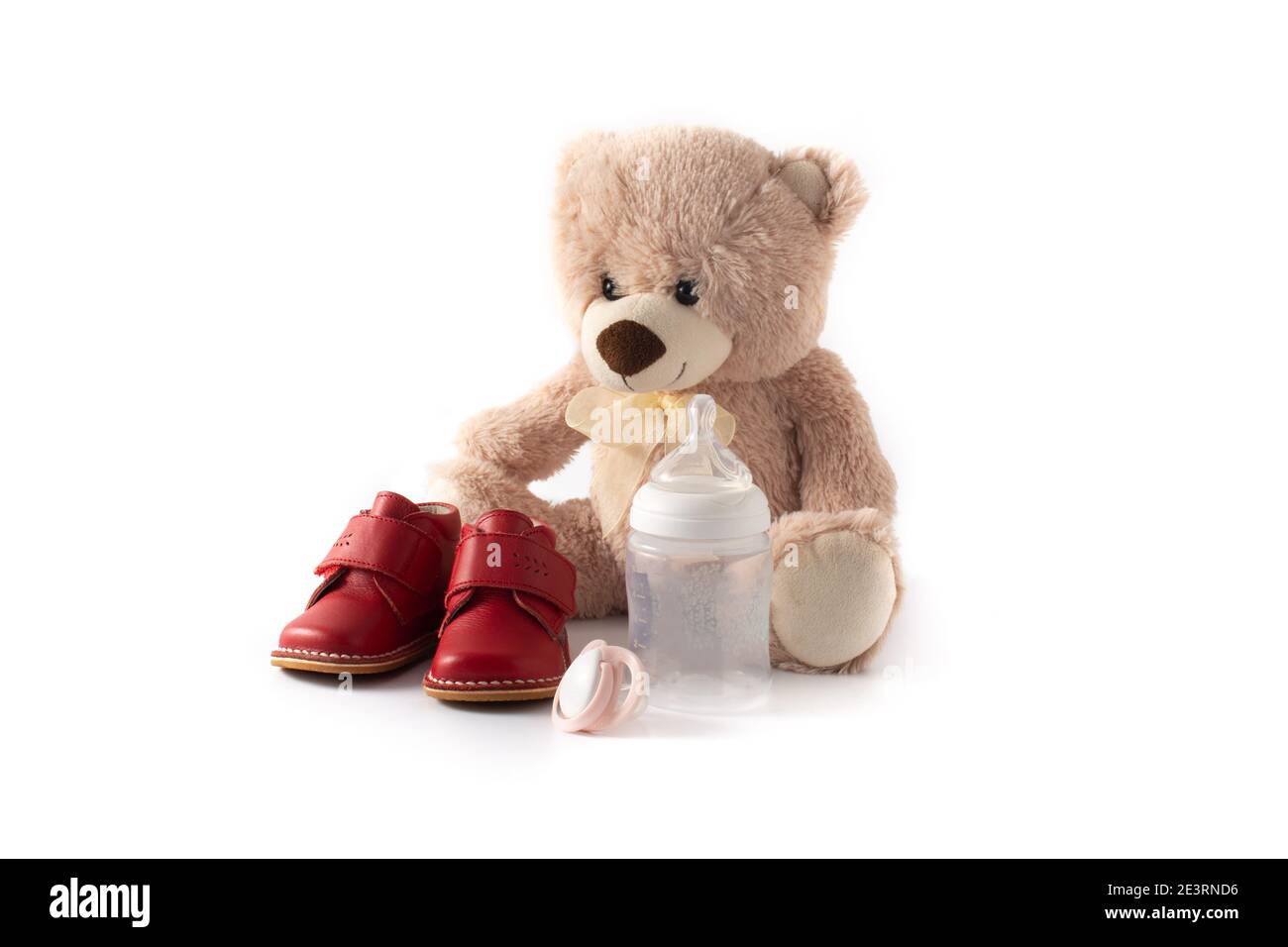 Teddy bear, pacifier,feeding bottle and shoes isolated on white ...