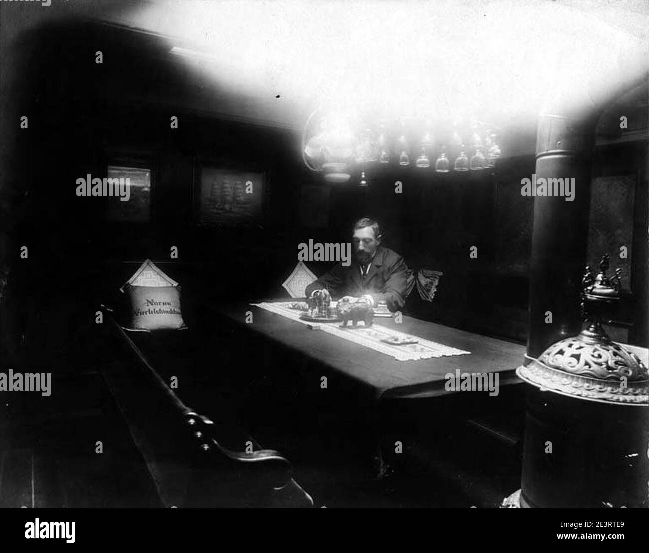Man writing at table, interior of unidentified ship, Washington, ca ...