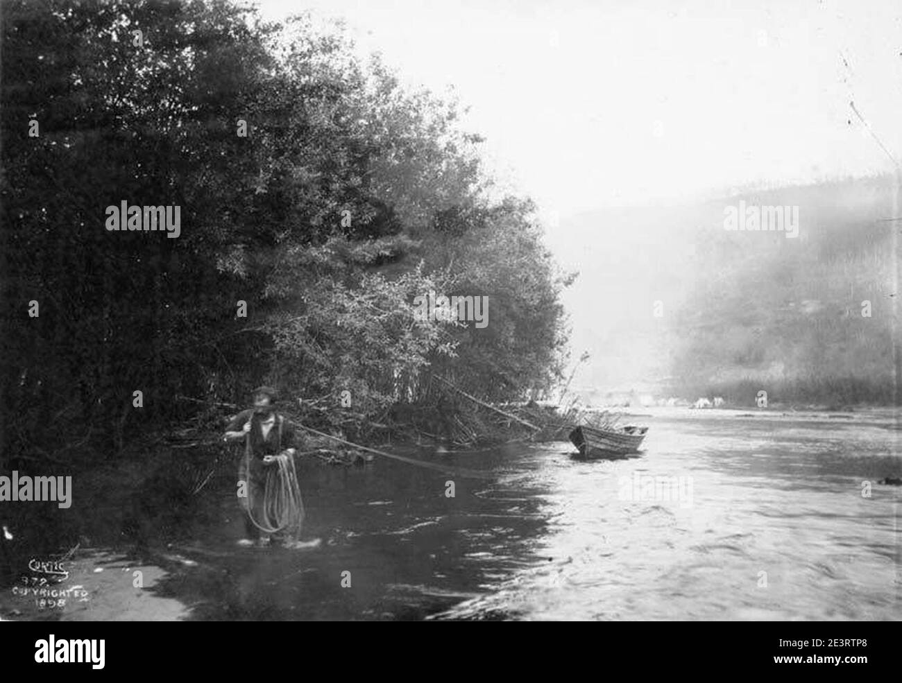 Man hauling boat up the Klondike River outside Dawson, ca 1898 Stock ...