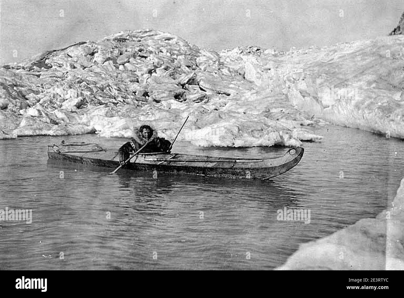 Man, possibly Eskimo, in a kayak, with ice floes in background ...
