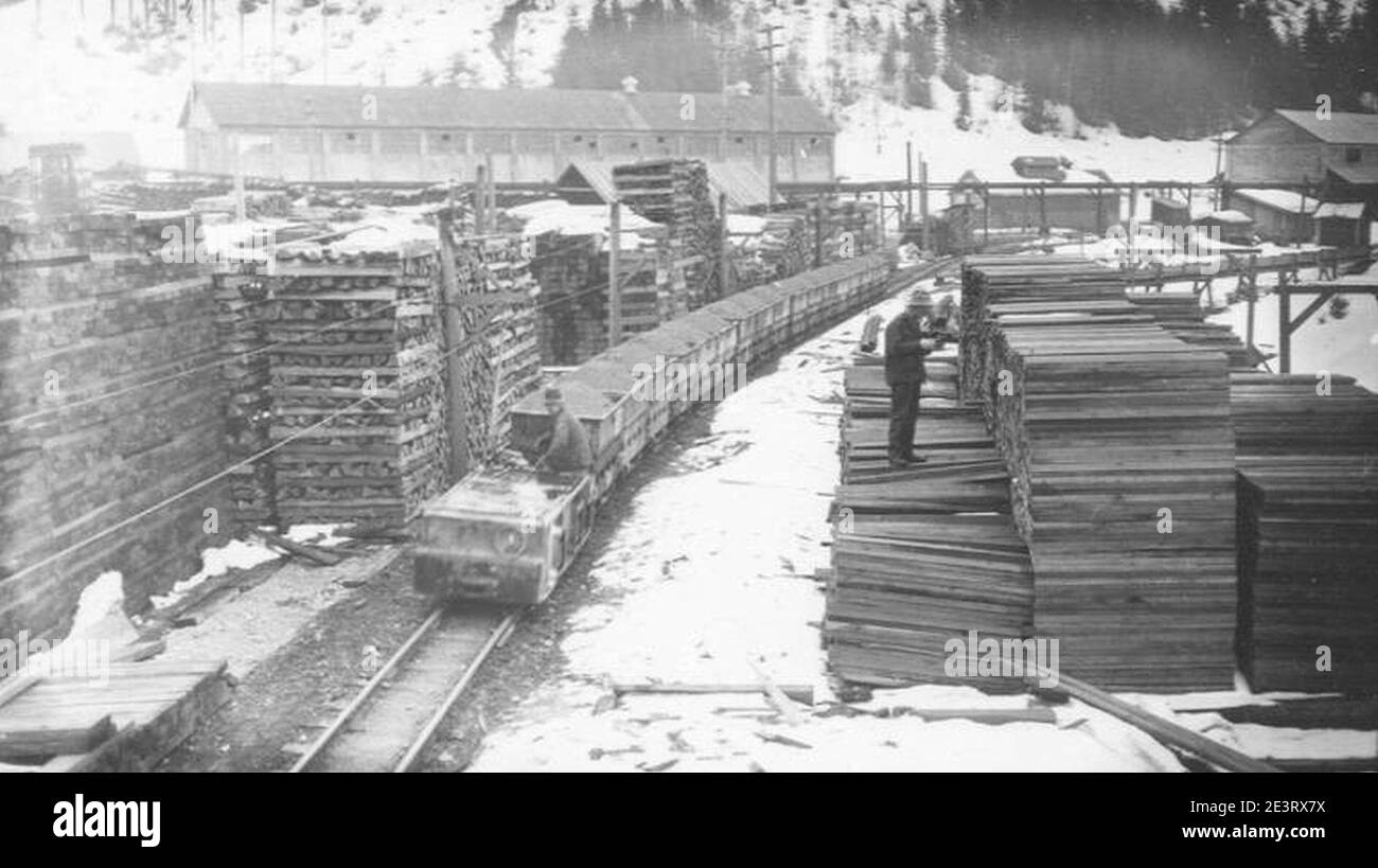 Man steering full mining train through stacks of lumber, 1917 (INDOCC ...