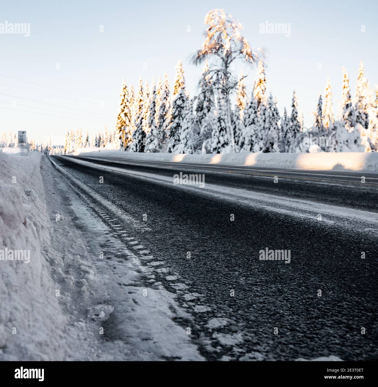 Icy winter road with rugged dark asphalt. Blurred out background Stock ...