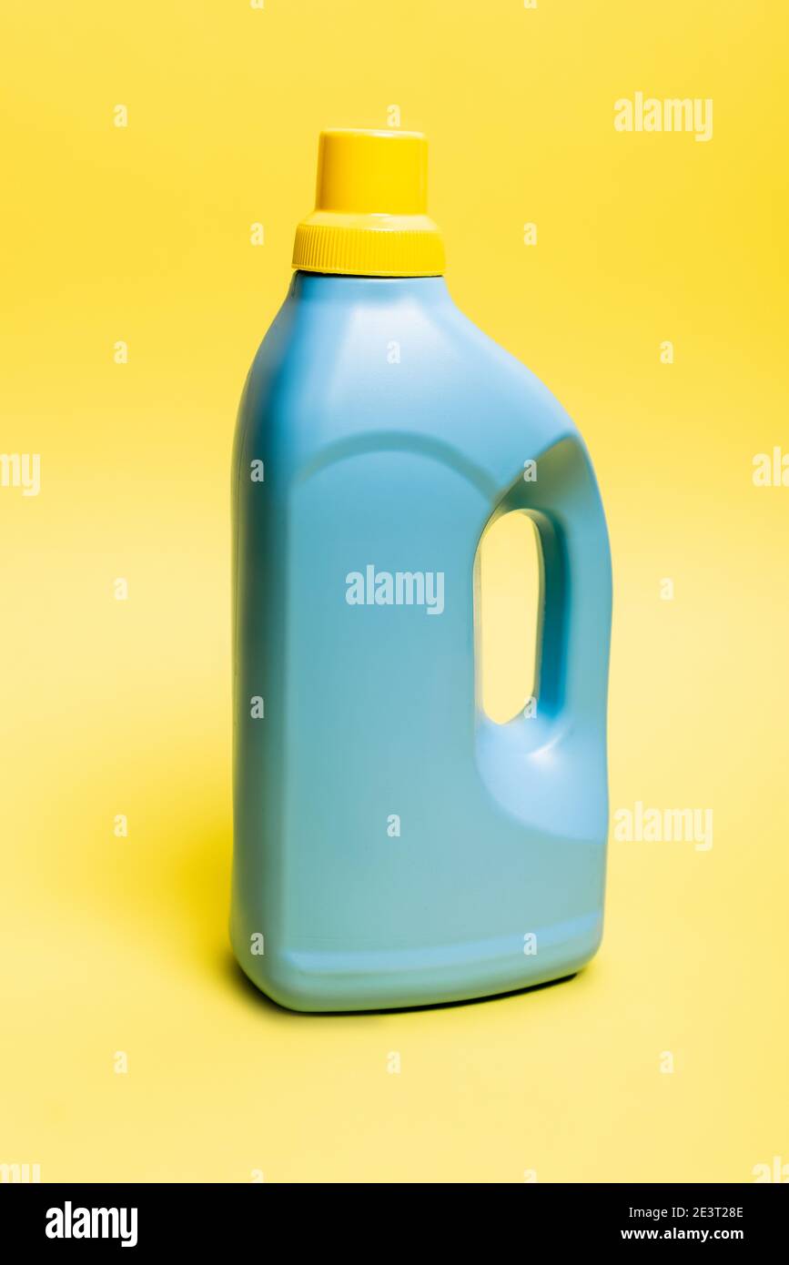 Blue bottle of detergent on yellow background Stock Photo - Alamy