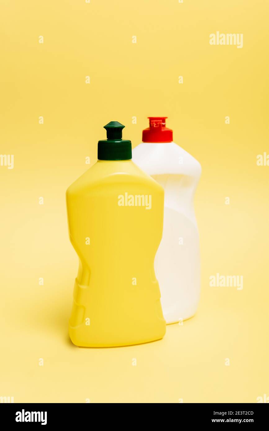 Bottles of dishwashing liquid on yellow background Stock Photo - Alamy