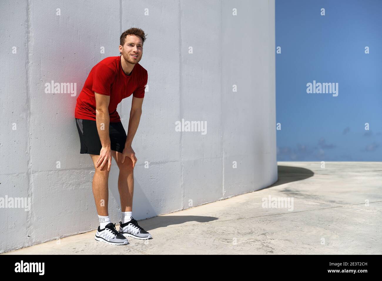 Tired male athlete runner exhausted of cardio workout breathing hard ...