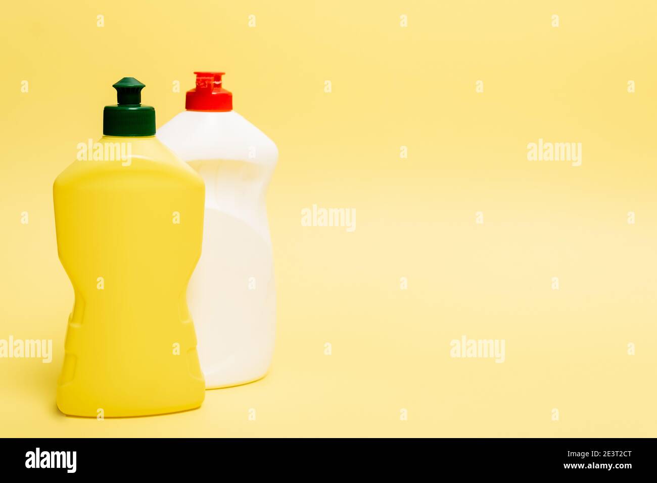 Bottles of dishwashing liquid on yellow background with copy space ...