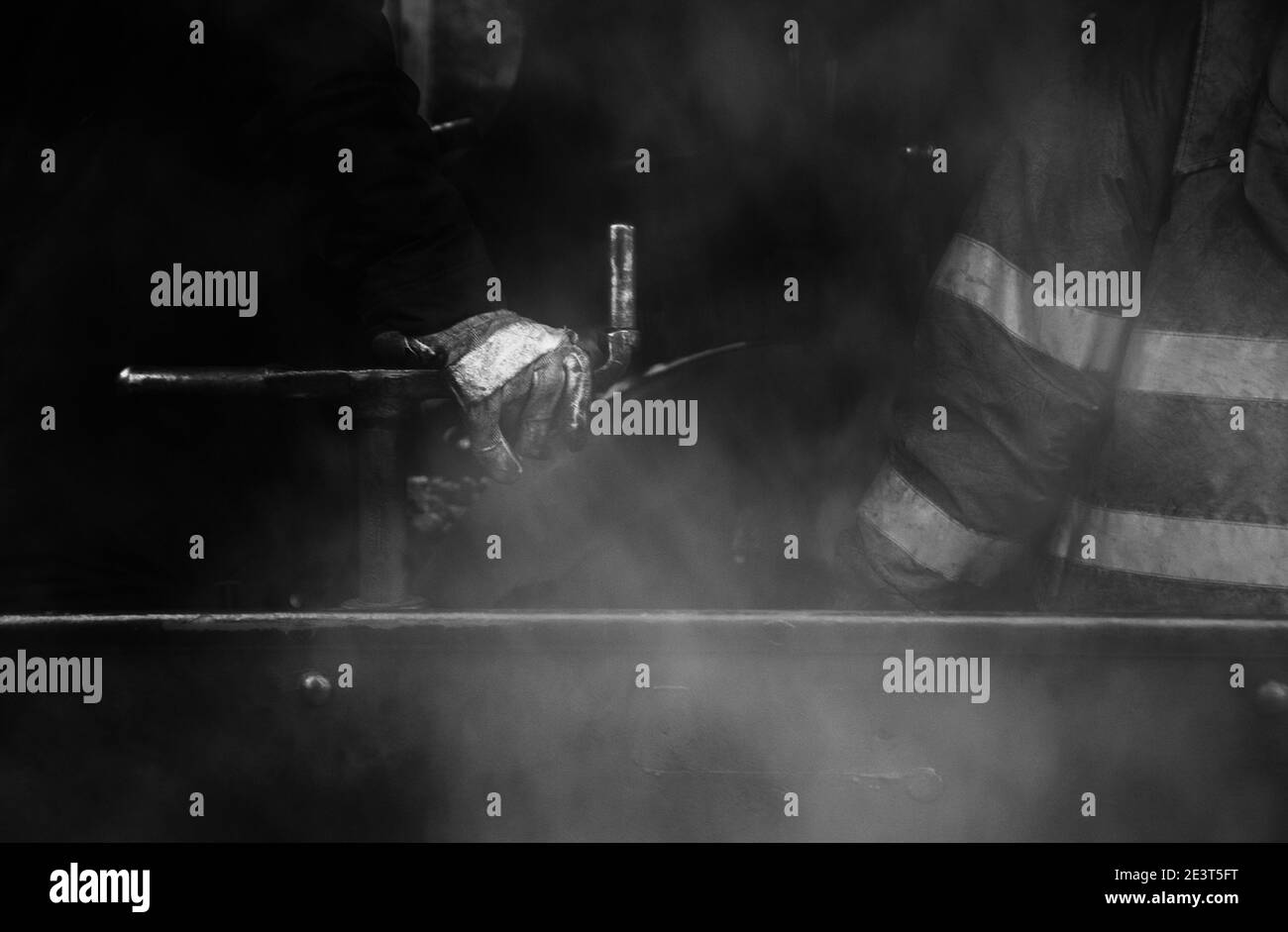 Steam train driver and fireman during their work. Back view. Closeup of ...