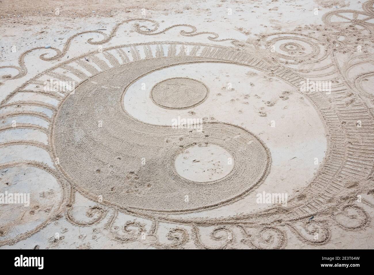 Decorative yin and yang drawing on the sand. Beach vacation leisure ...