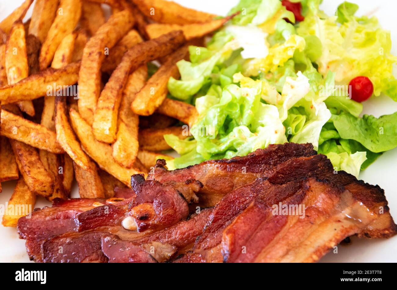 Grilled pork belly, chips and green salad. Simple traditional meal ...
